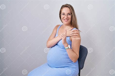 Young Pregnant Woman Wearing Band Aid For Vaccine Injection Surprised