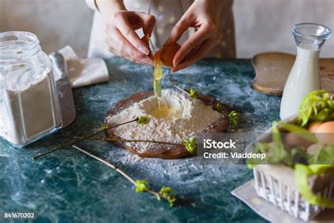 Pembuat Roti Menuangkan Telur Ke Dalam Corong Dalam Tepung Di Atas Meja