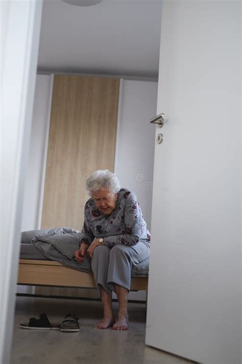 Anciana Tratando De Levantarse De La Cama Sintiendo Dolor Foto De