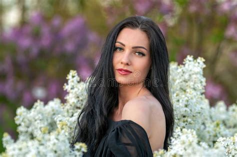 Woman With Long Black Hair Posing In A Garden Background With