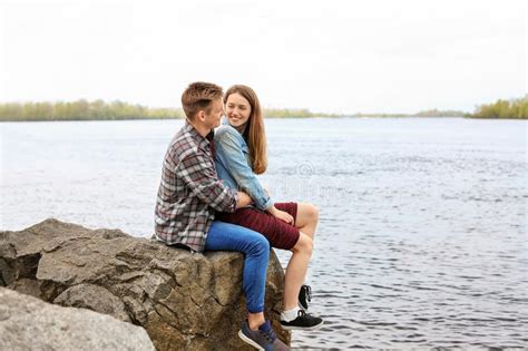 Happy Young Couple Sitting Near River On Spring Day Stock Image Image