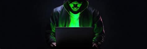 Premium Ai Image Hacker Without Face In A Hood Holds A Laptop On A Background Banner For Cyber