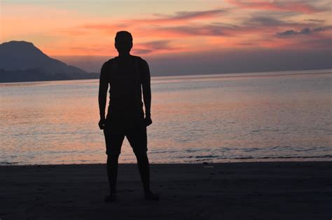 Vista Trasera De Un Hombre En Silueta De Pie En La Playa Durante La