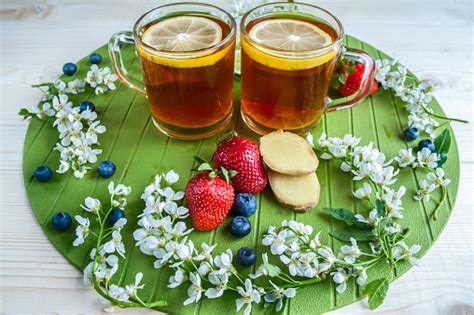 차 배경 평면도 텍스트에 대 한 공간 블랙 티와 레몬 생강 라임 민트 라이트 그린 민트 배경 백색 체리 꽃으로 장식 되어 있습니다 식품 산업 차 포장 레스토랑 사업 0명에