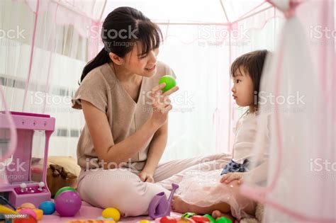 아시아 의 어머니는 집에서 텐트에서 색상에 대해 어린 소녀 딸을 가르칩니다 아름다운 사랑하는 부모는 배우고 말하기 기술을 개발하기 위해 작은 아이와 교육 게임을 재생합니다