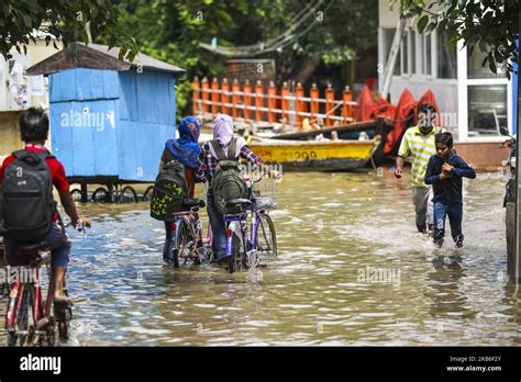 Guys Walk On The Street Submerged By The Monson Rains In Varanasi City