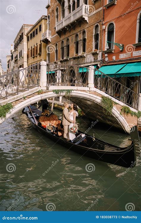 Italy Wedding In Venice A Gondolier Rolls A Bride And Groom In A