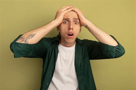 Free Photo Scared Young Blonde Guy Wearing Green T Shirt Grabbed Head