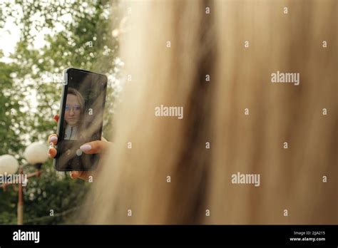 Happy Flirting Young Girl Takes A Photo Of Herself On A Smartphone In