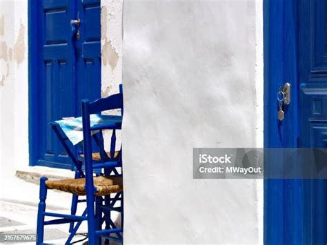 파란 문 하얗게 칠해진 벽에 놓인 파란 테이블과 의자 그리스 여름의 전형적인 색 세리포스 섬 그리스 자갈 건축자재에 대한 스톡 사진 및 기타 이미지 Istock