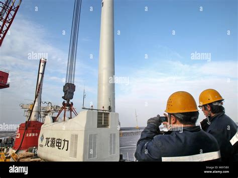 File Chinese Workers Look At A Wind Turbine Of China Longyuan Power
