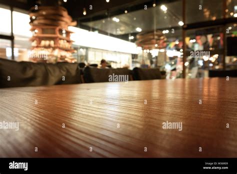 Empty Wooden Bar Counter With Reflect On Blur Of Lighting In Night
