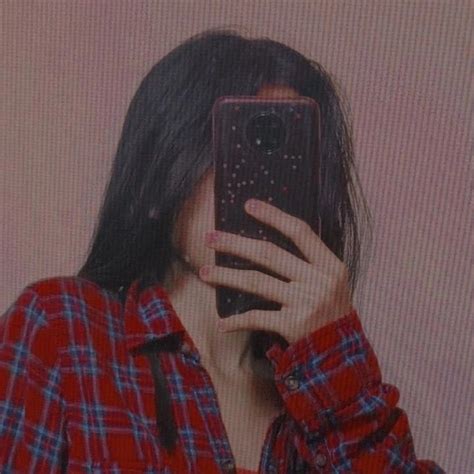 A Woman Taking A Selfie With Her Cell Phone While Wearing A Red Plaid Shirt