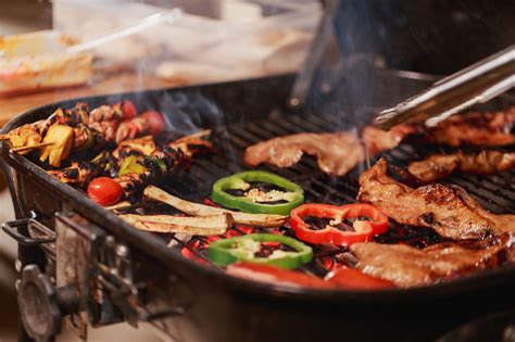 밤에자연이 열리는 난로 야외 캠핑에서 불꽃이 불로 바비큐 그릴 고기를 닫습니다 Barbecue Social Gathering