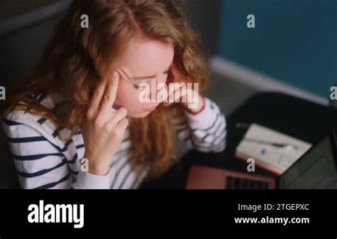 Overworked Woman Works With Laptop At Home Massaging Temples Suffering