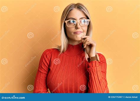 Beautiful Blonde Woman Wearing Casual Clothes And Glasses Thinking