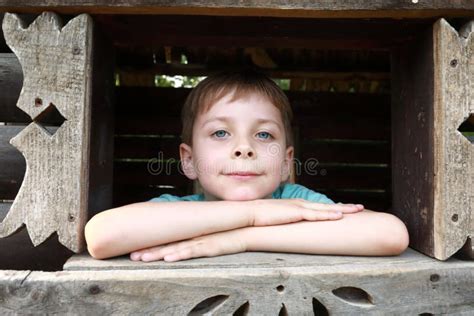 Niño Mirando a Través De Una Ventana Abriendo Una Casa De Madera Foto