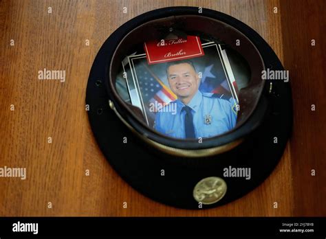 A Program Is Shown Inside A Firefighters Hat During The Funeral For