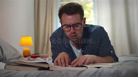 Young Man Reads Books Lying On Bed Realtime Stock Footage Video Of Eyeglasses Learning