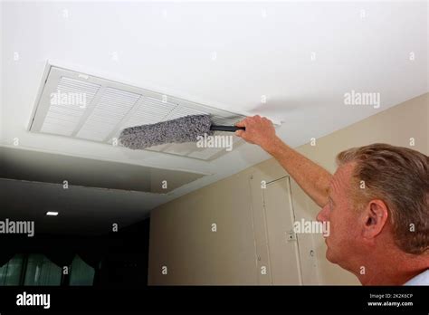 Dusting Hvac Intake Vent Grid By Adult Man To Reduce Allergens Stock
