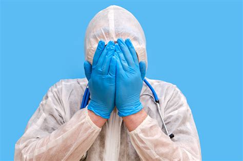 스튜디오 블루 배경에 고글과 얼굴 마스크가달린 보호복 유니폼을 입은 남자 의사 메딕 N95 호흡보호구 및 안전 안경을 착용한