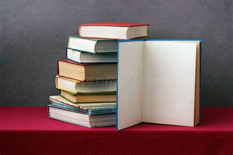 Стог книг на таблице одной раскрытой книги Стоковое Изображение