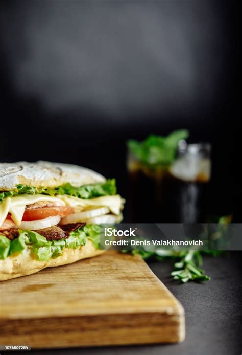 검은 배경 로즈마리 오이 나무 보드 길거리 음식에 몇 가지에 대 한 큰 샌드위치 패스트푸드 쇠고기와 함께 수 제 햄버거 나무 테이블에 치즈 얼음 콜라의 유리 민트 0명에