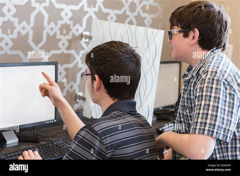 Teenage Brothers Playing With Their Computer Gadgets At Leisure Time