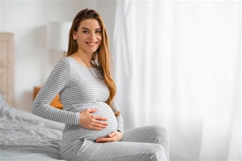 Premium Photo Expectant Mom Smiling On Bed