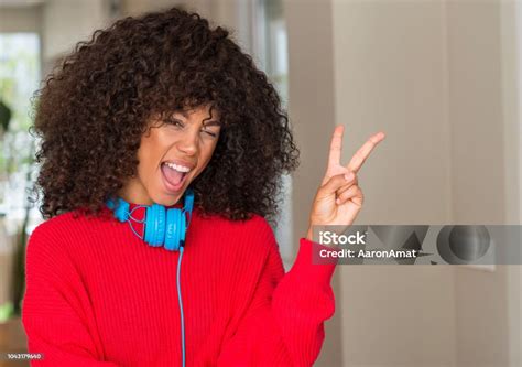 승리 표시를 하 고 카메라에 윙크 하는 행복 한 얼굴로 웃 고 헤드폰을 착용 하는 아프리카계 미국인 여자 번호 2입니다 검은색에 대한 스톡 사진 및 기타 이미지 Istock