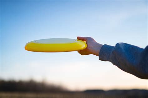Hand Holding Yellow Frisbee Outside Flaying Frisbee Outdoors Wi
