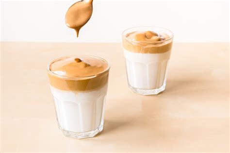 달곤에서 커피를 만드는 방법 단계별 사진 지시 7단계 우유에 크림을 넣으세요 재료 인스턴트 커피 설탕 물 우유 및 나무 배경에