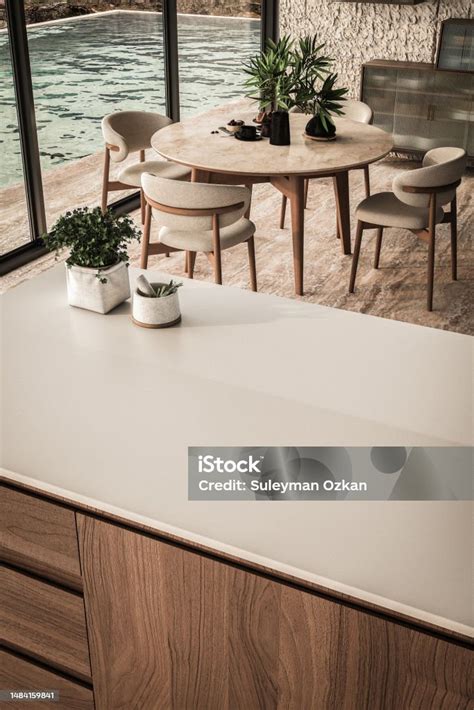 제품 진열을 위한 우아한 아일랜드 조리대 조리대 위의 녹색 식물 수영장이 내려다보이는 창가의 아름다운 식탁이 특징인 멋진 주방 이미지입니다 3d 렌더링 가구에 대한 스톡