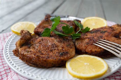 Breaded Pork Chops With Parmesan Parsley Crust On A Plate With Lemon
