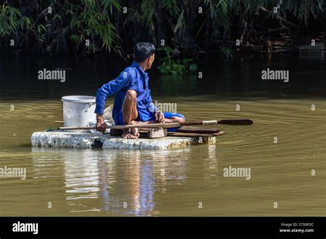 Thailand Dec 05 2023 Man Floating On Styrofoam Inspects Riverbank