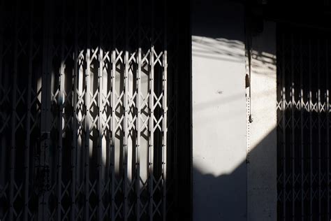 A Metal Security Gate With A Lattice Design Partially Illuminated By