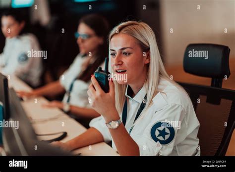 Female Security Operator Holding Portable Radio In Hand While Working