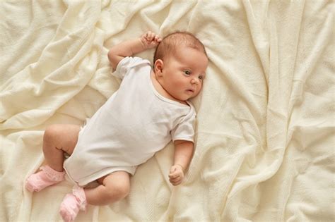 Bébé nouveau né fille ou garçon couché sur une couverture sur le lit en