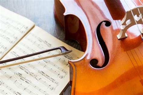 Cello Dan Busurnya Dengan Lembaran Musik Di Latar Belakang Kayu Dengan