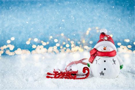 Boneco de neve trenó vermelho na neve Foto Premium