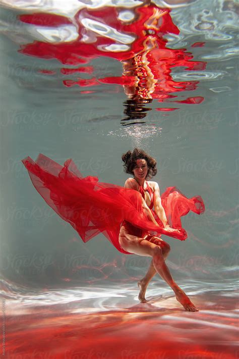 Graceful Lady In Scarlet Dress Posing Underwater By Stocksy