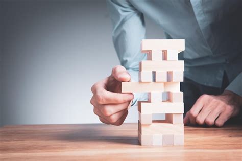 Premium Photo Closeup Of A Businessman Making A Structure With Wooden