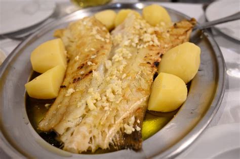 Grilled Fillet Of White Codfish Served With Potatos In Fish Restaurant