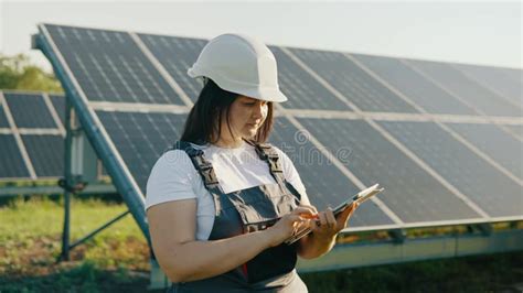 female engineer with digital tablet working at a power plant with solar
