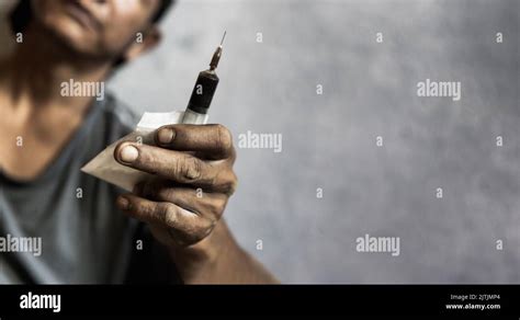 Human Hand Of A Drug Addict And A Syringe With Narcotic Syringe Lying