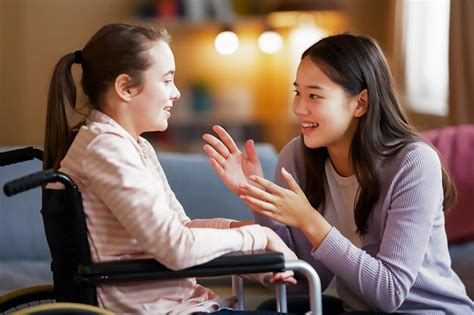 Premium Photo A Girl Talking To A Girl In A Wheelchair With A Hand On