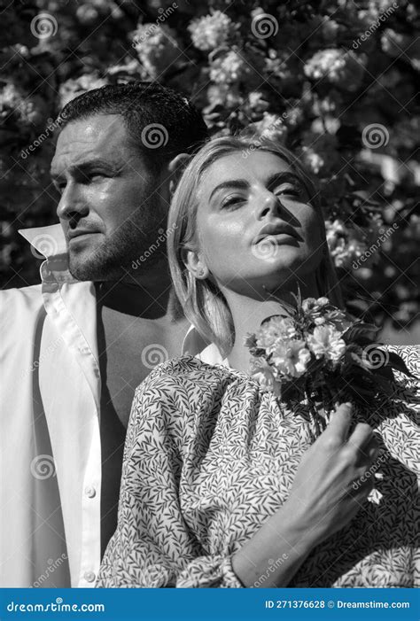 Sensual Woman And Man In Pink Flowers In Summer Blossom Park Stock
