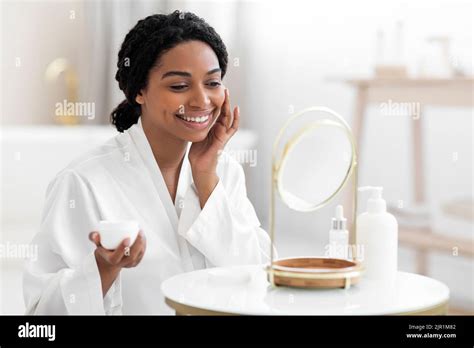 Beauty Rituals Attractive Black Woman Applying Moisturising Cream On