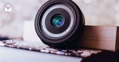 검은 캐논 카메라 렌즈는 흰 책에 기대어 있습니다 사진 Unsplash의 무료 바르샤바 이미지