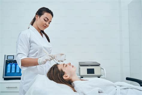 스킨케어 마스크를 착용하는 것을 즐기면서 얼굴에 미소를 짓는 친절한 여성 사진 Unsplash의 바디 케어 이미지
